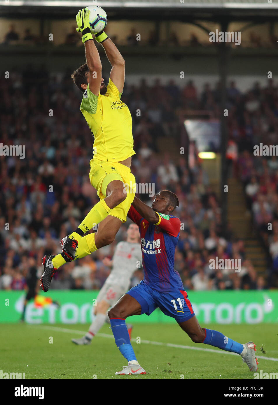 Alisson Becker of Liverpool gathers the ball under pressure from ...