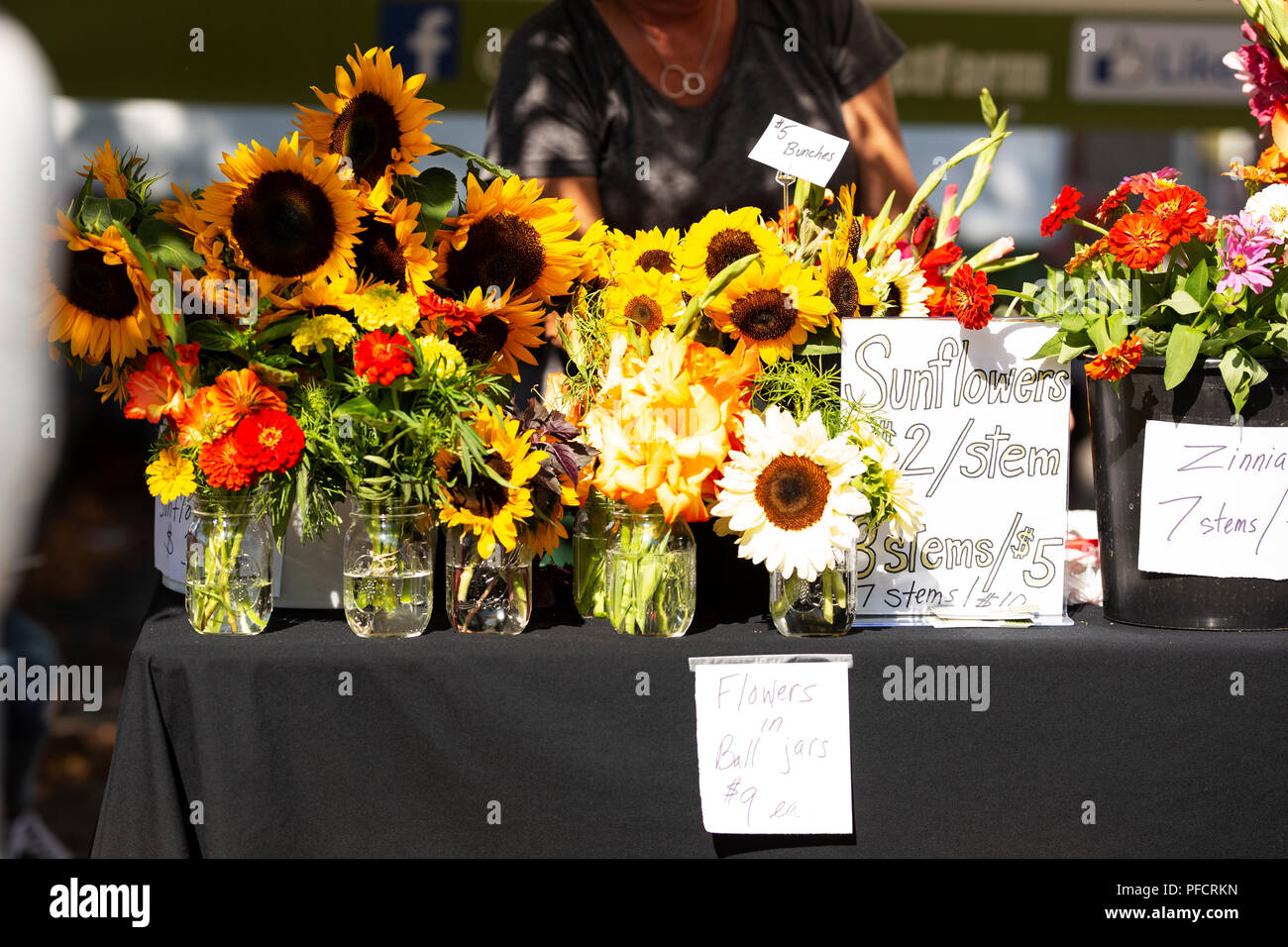 A display of sunflowers and other colorful summer flowers at a farmer's ...