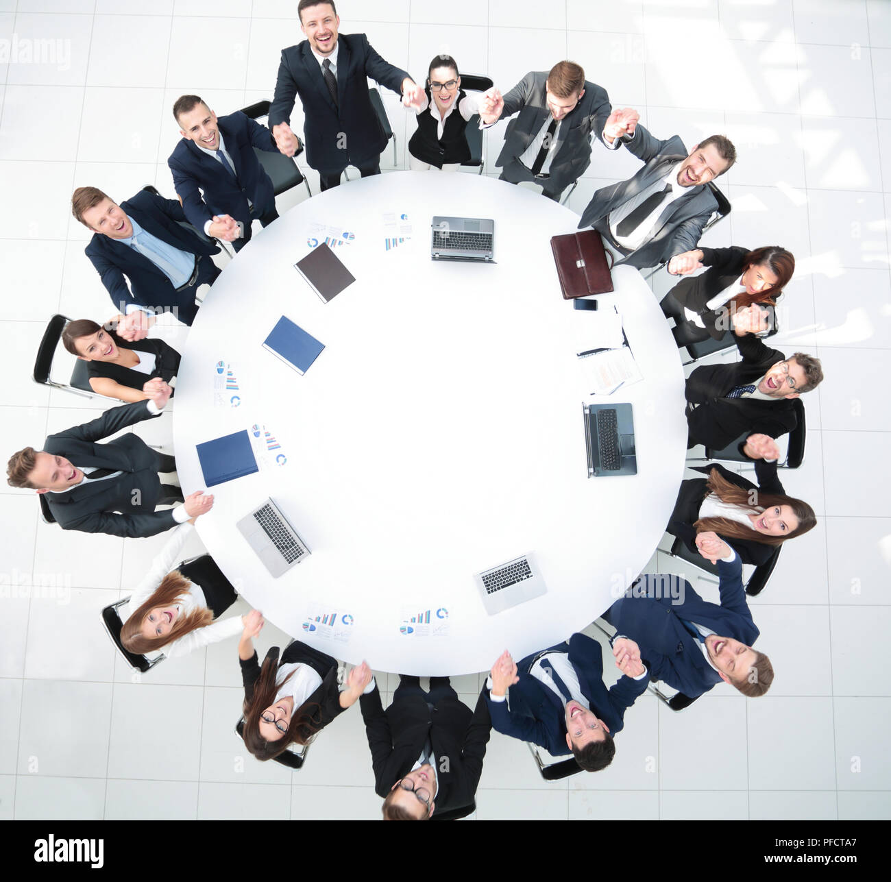 large business team sitting at the round table and raising his hands up ...