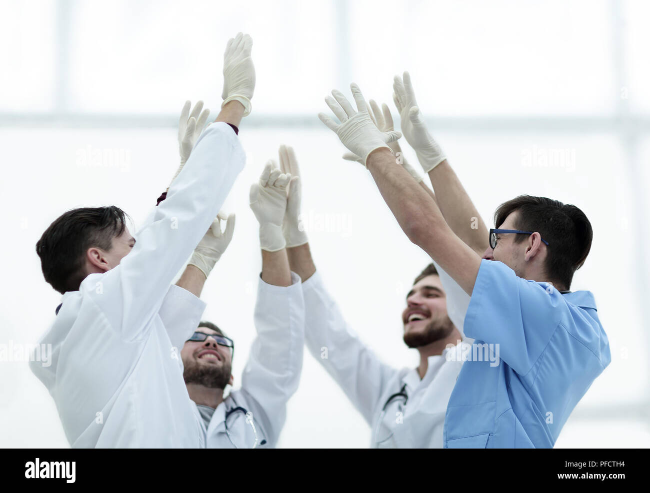 surgical team raising their hand Stock Photo - Alamy