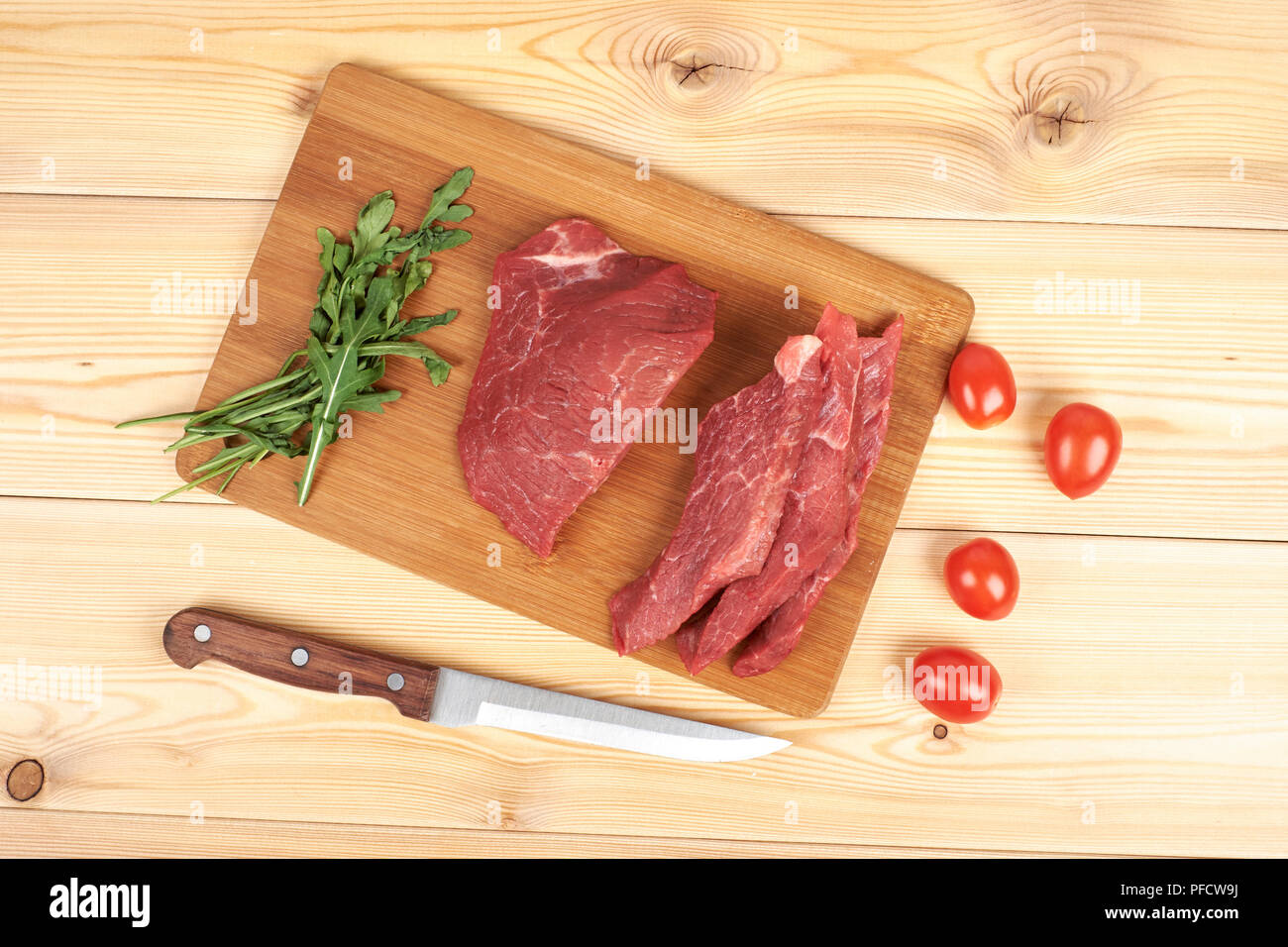 Sliced raw beef on cutting board and vegetables Stock Photo - Alamy
