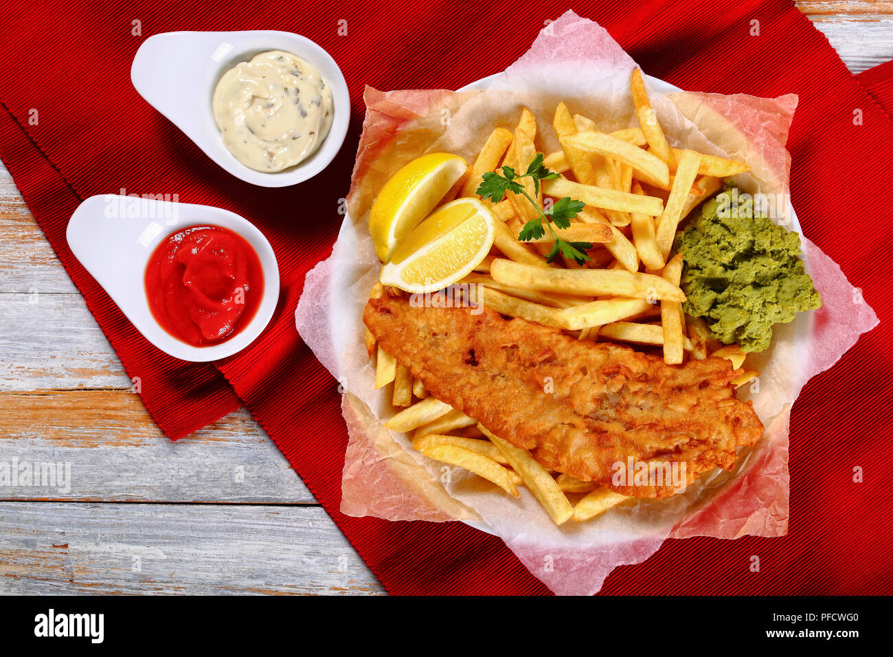 crispy fish and chips - fried cod, french fries, lemon slices, tartar ...
