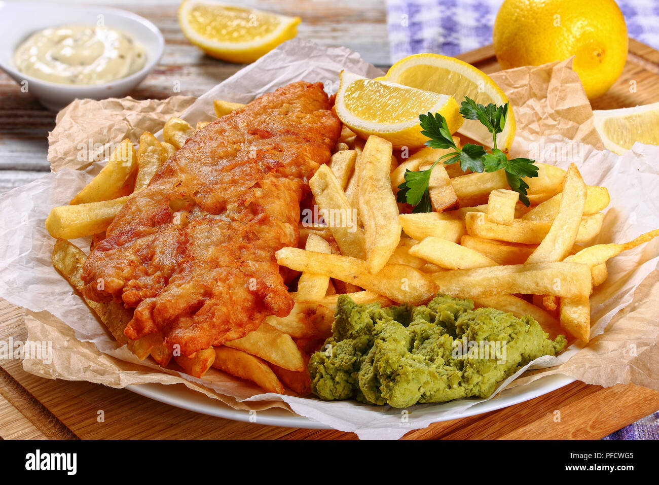 crispy fish and chips - fried cod, french fries, lemon slices, tartar ...