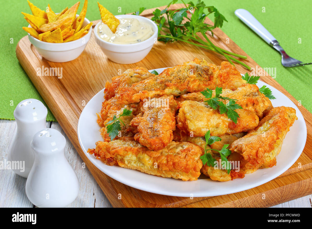 delicious golden batter fried perch served on white plate on wooden ...