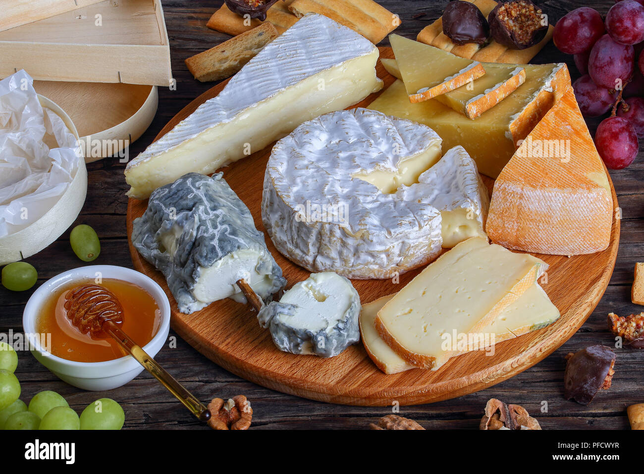 french Cheese plate served with grapes and nuts on wooden background ...