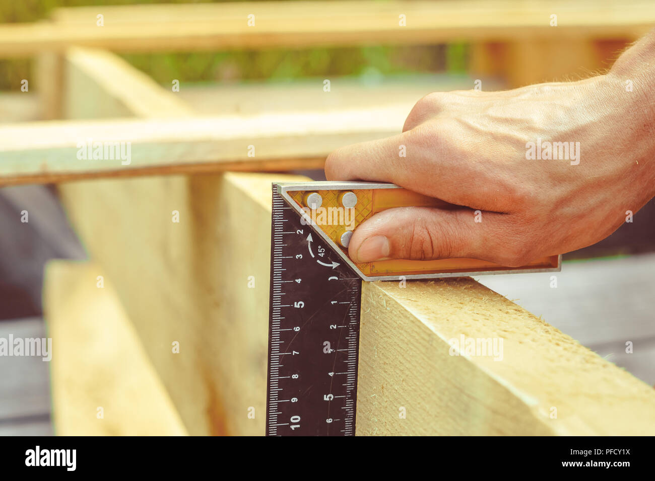 The worker makes measurements of a board with the help of a ruler, a ...