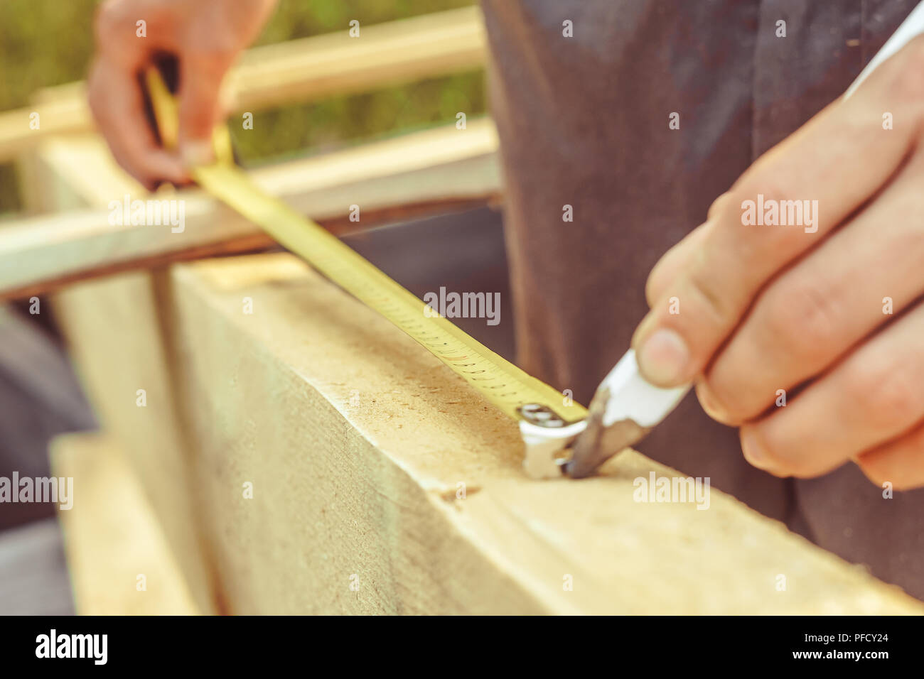 The worker makes measurements of a board with the help of a ruler, a ...