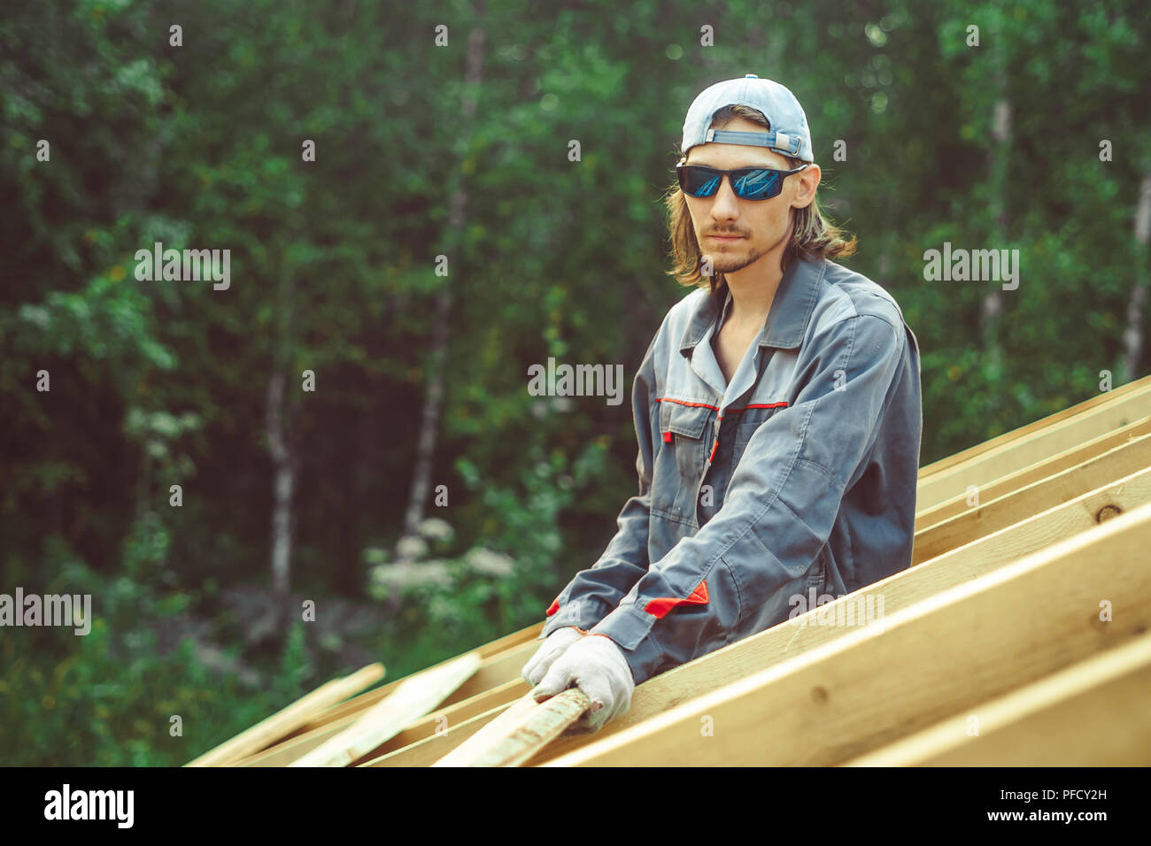 worker roofer builder working on roof structure on construction site ...