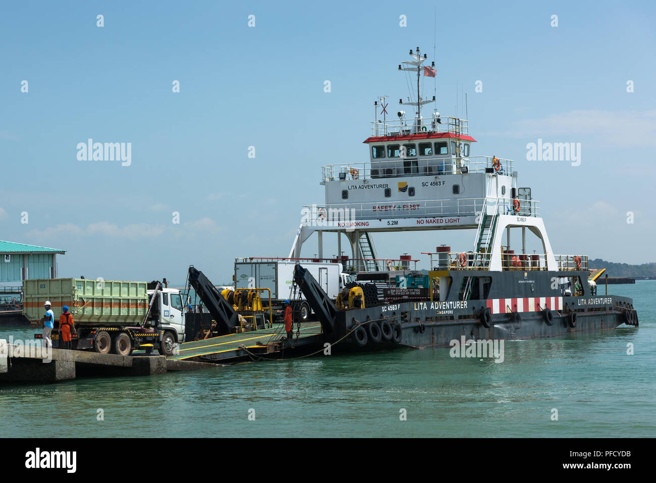 Vessel “Lita Adventurer” loading trucks at a ferry terminal in Changi ...