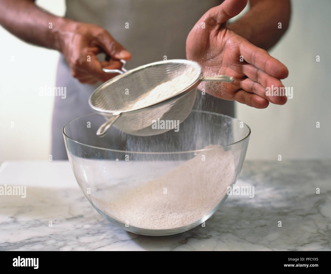 Flour being sieved into a glass bowl Stock Photo - Alamy