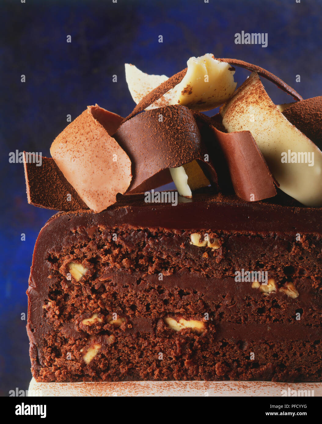 Cross-section of iced chocolate layer-cake decorated with chocolate ...