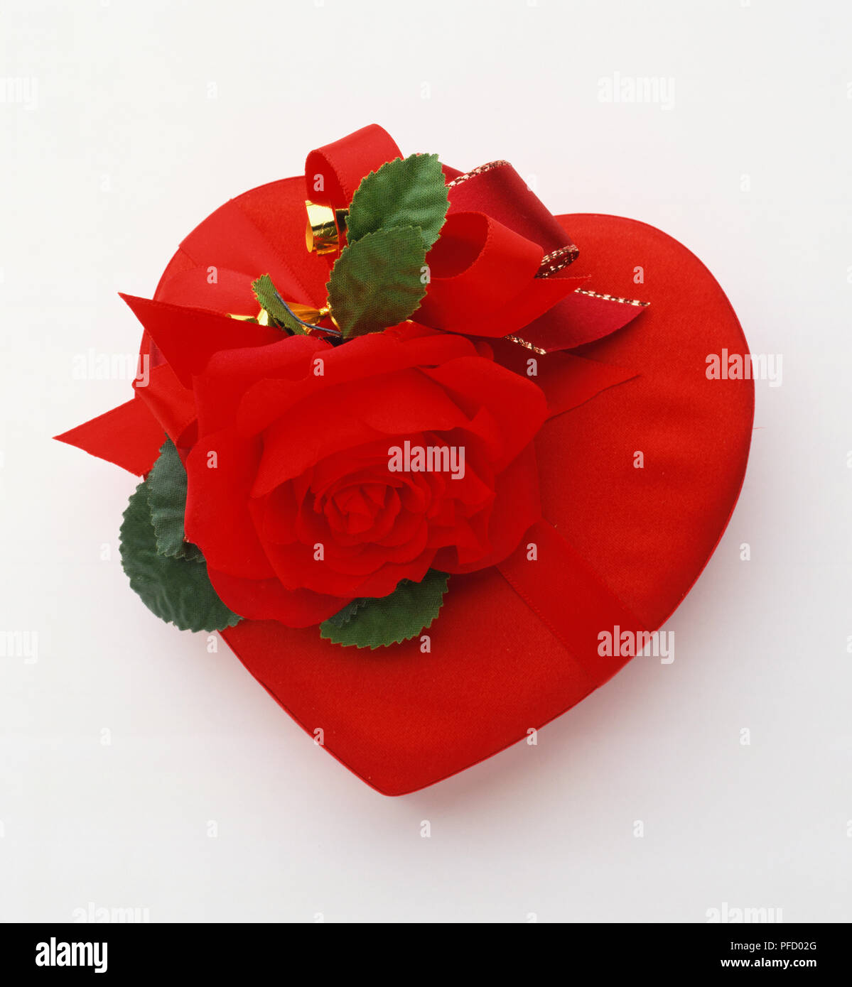 Present in heart-shaped box wrapped in red paper, red and gold ribbon ...