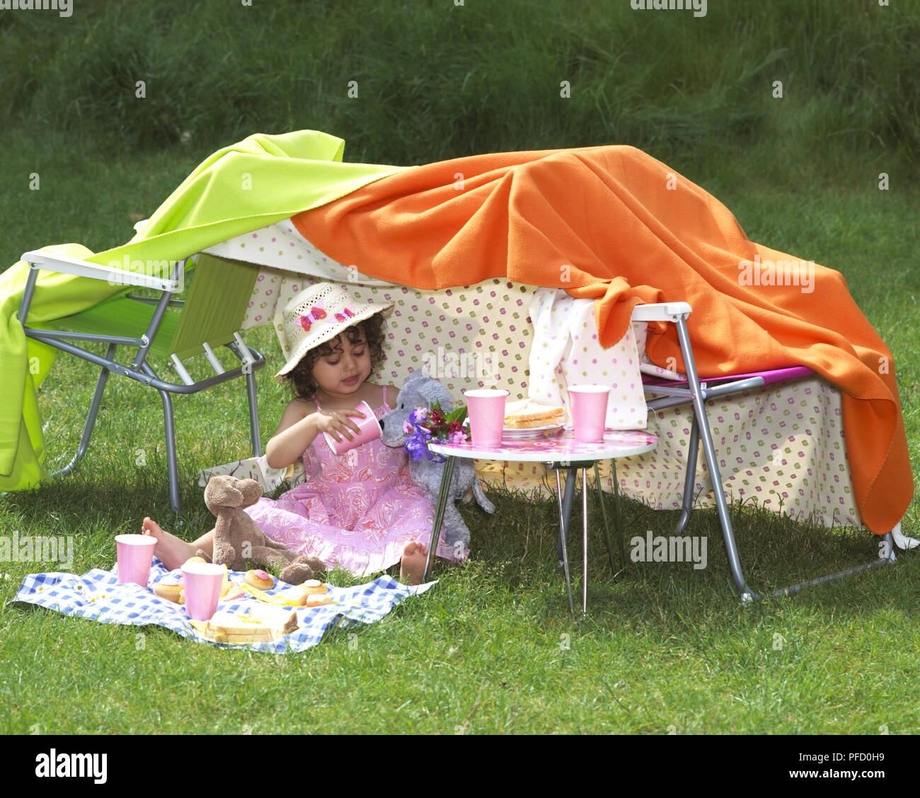 Makeshift tent made from chairs and blankets, girl sitting under tent ...