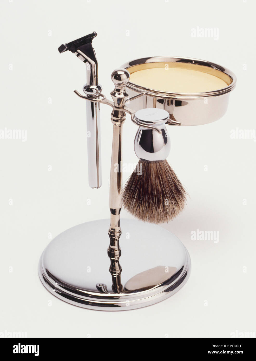 Chrome stand holding wet shaver, brush and soap dish, front view Stock ...