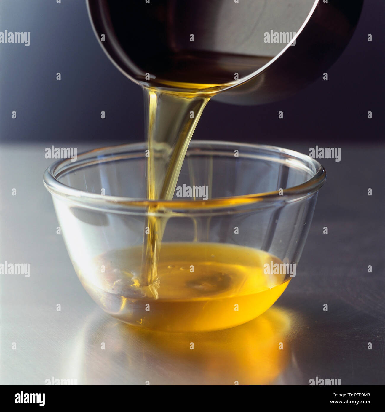 Pouring clarified butter from pan into glass bowl Stock Photo - Alamy