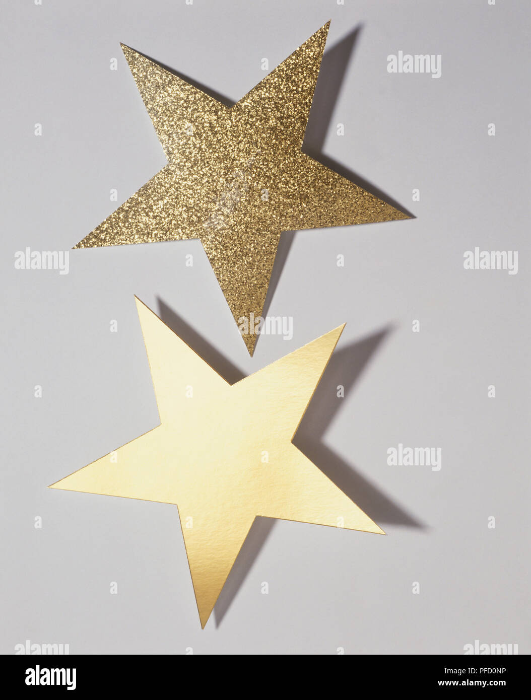 Two gold stars, one smooth and the other with a glittery surface, view ...