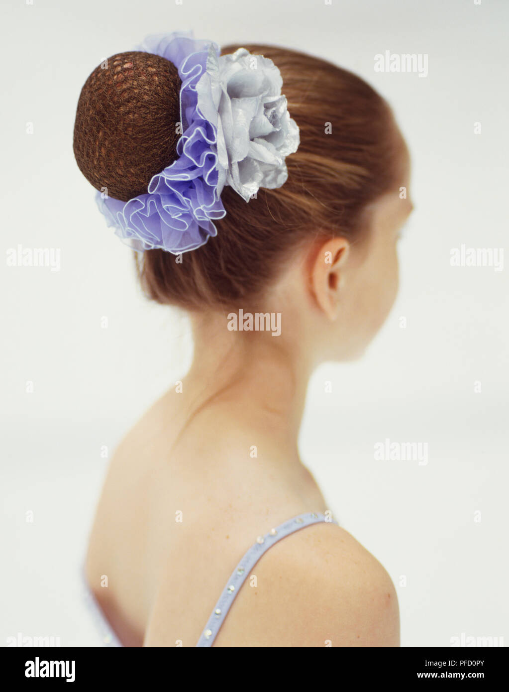 Girl in strapless top, strings embroidered with beads, hair tied in bun ...