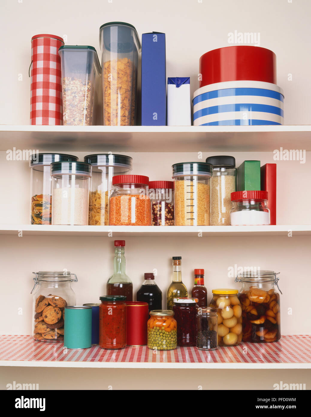 Three white storage shelves, red-white checked surface, holding various ...