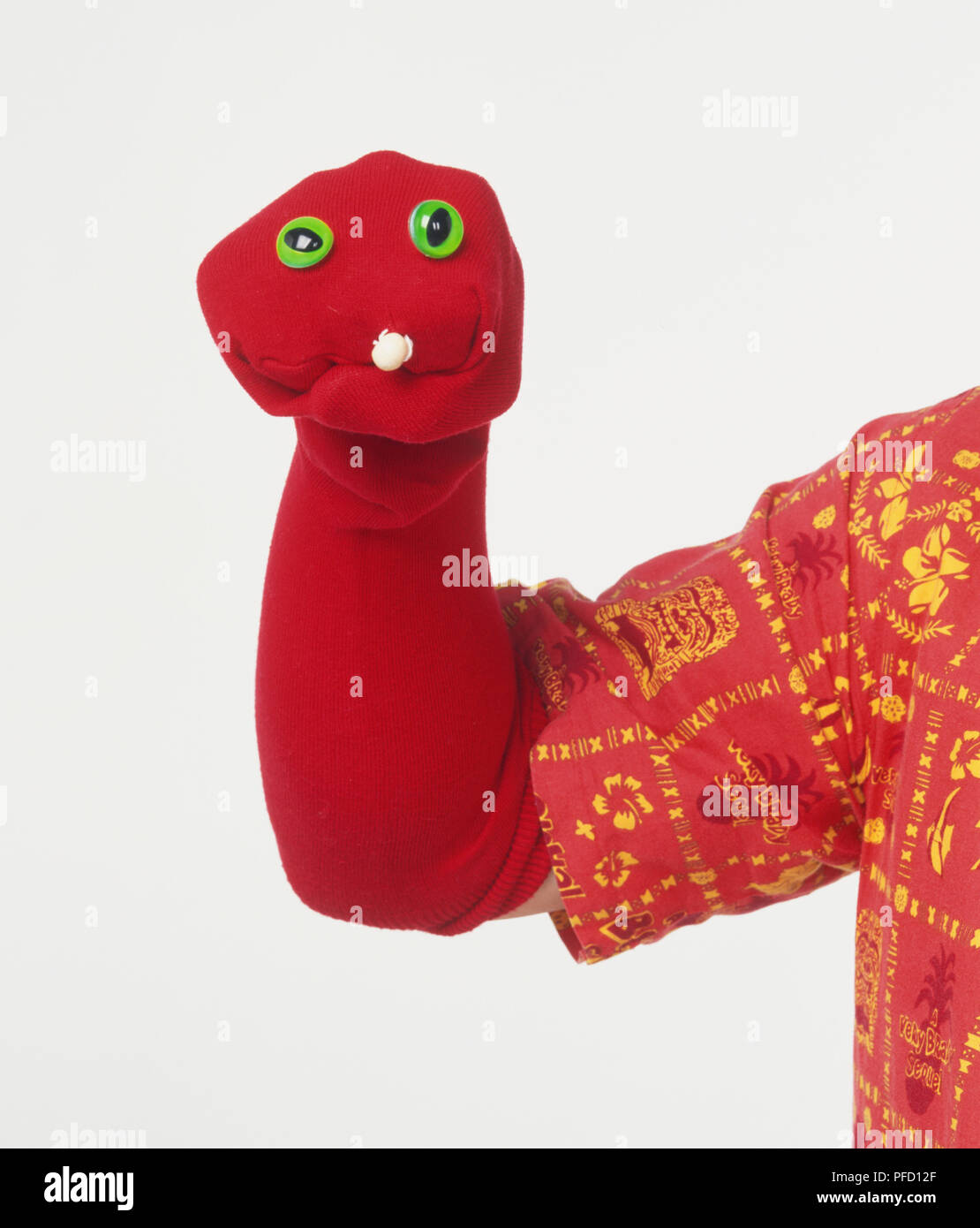 Adult wearing red hand puppet over left lower arm, held upright, making ...