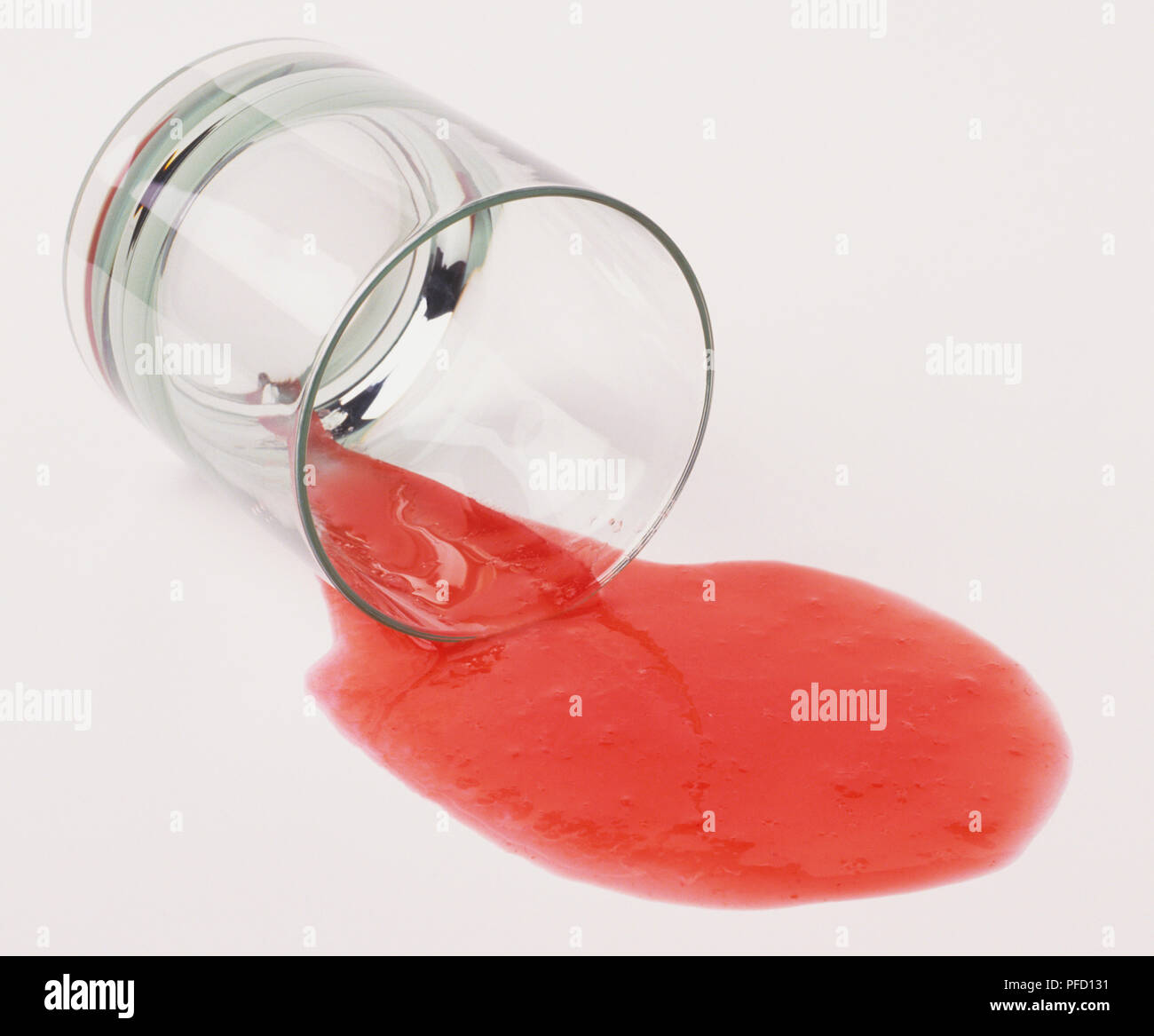 Red juice spilling from knocked-over glass, close up Stock Photo - Alamy