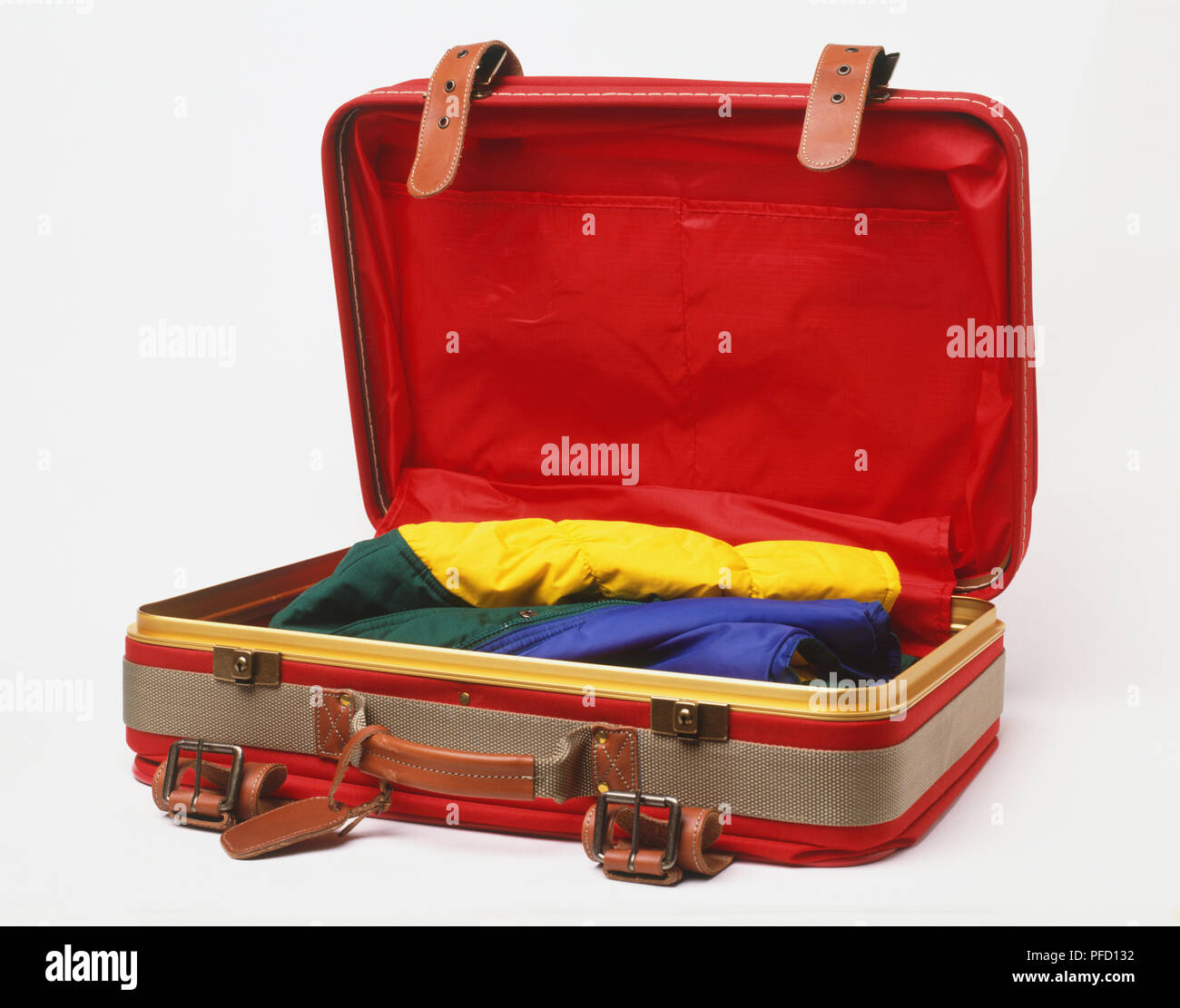 Open red suitcase containing folded colourful coat Stock Photo - Alamy