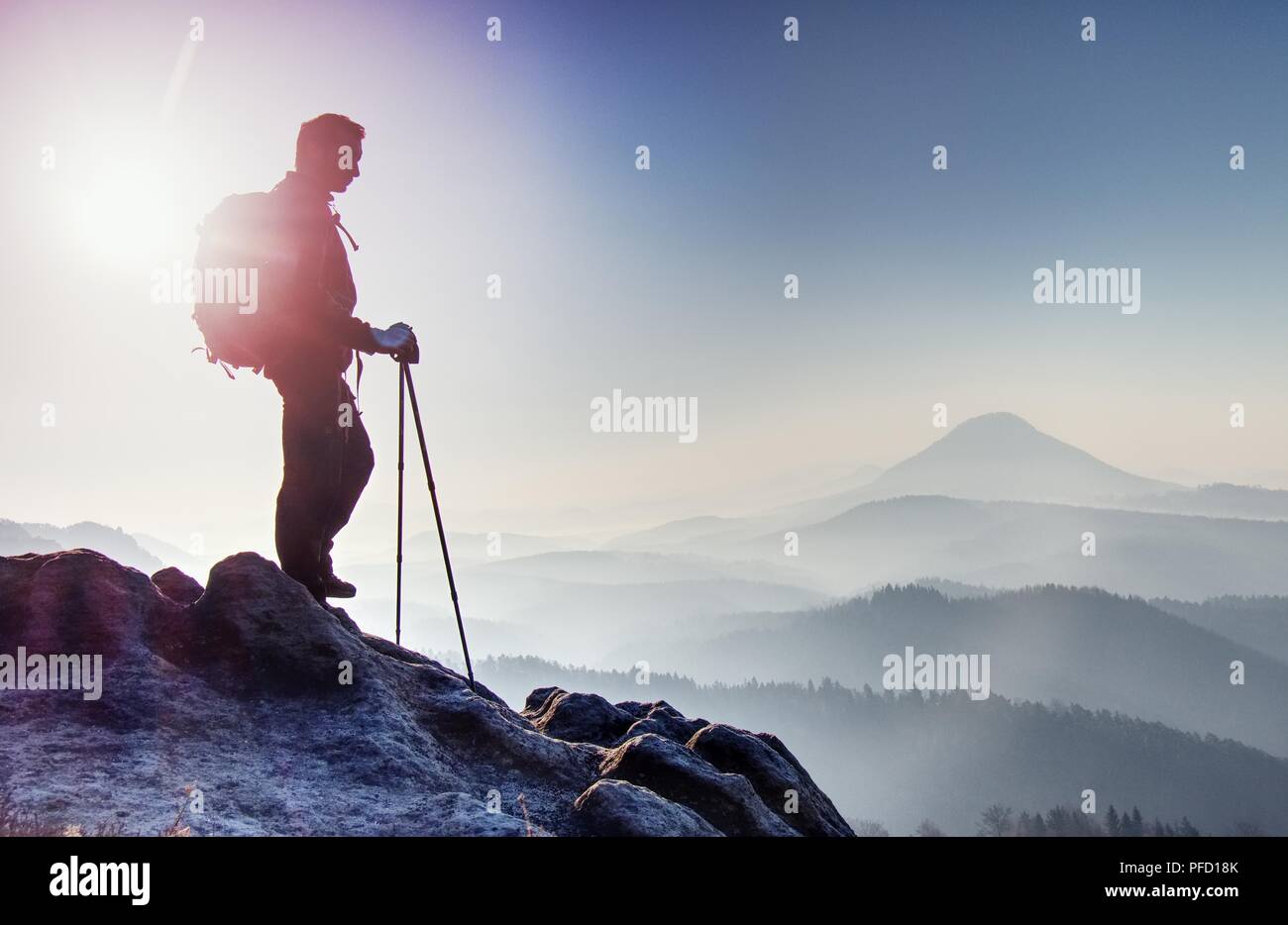 Tall hiker with backpack and trekking poles walk mountain trail. Rocky ...