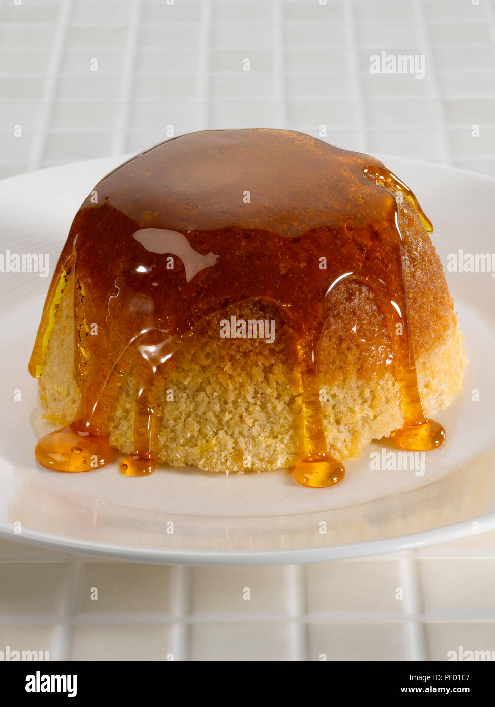 Steamed sponge pudding with syrup, on a plate, close-up Stock Photo - Alamy