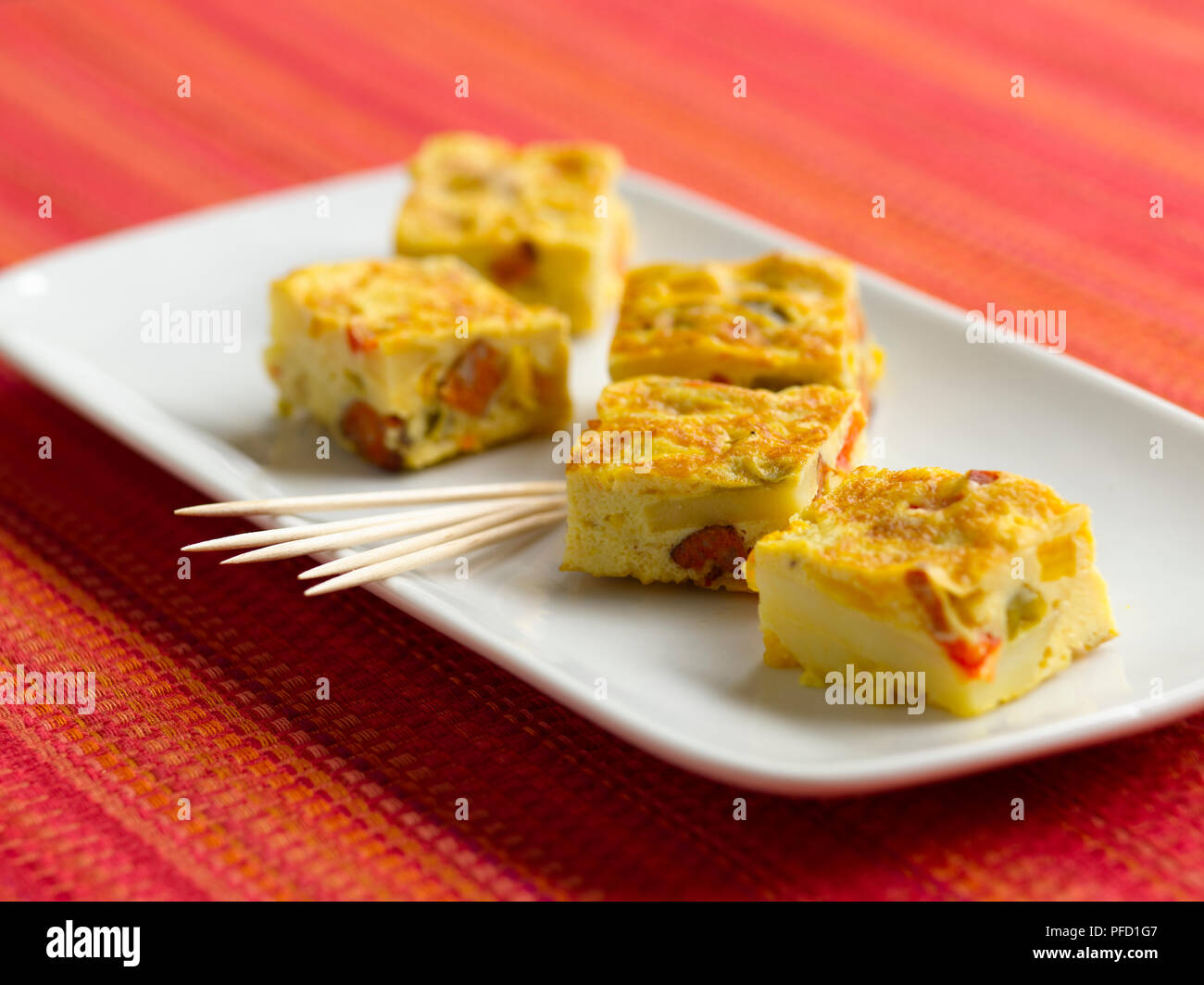 Tortilla espanola cut into bite sized pieces, with cocktails sticks ...