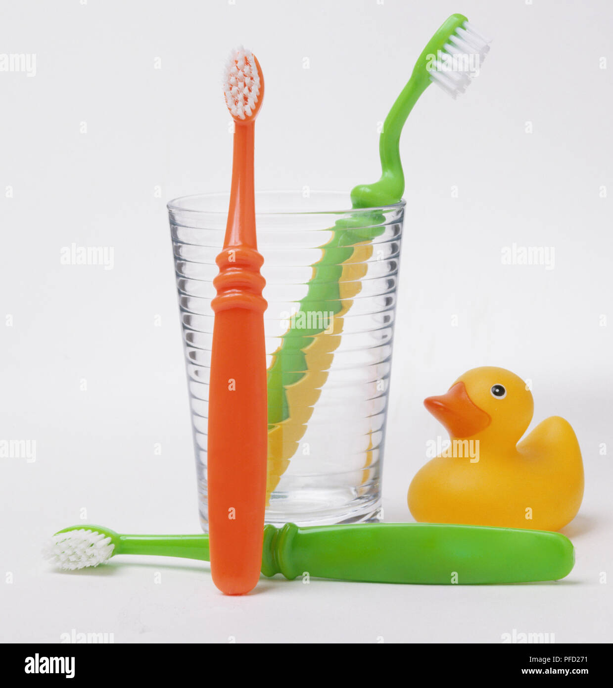 Three colourful toothbrushes with illustrated handles and a yellow ...
