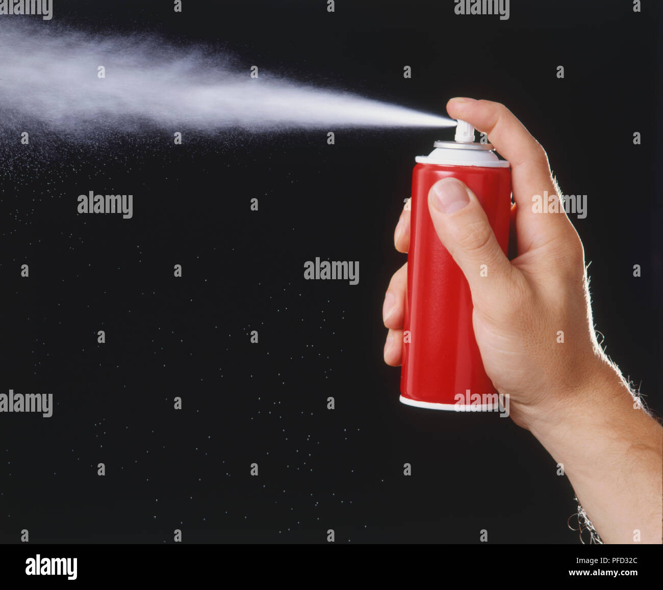 Pushing sprayer button on red aerosol can to produce white mist Stock ...