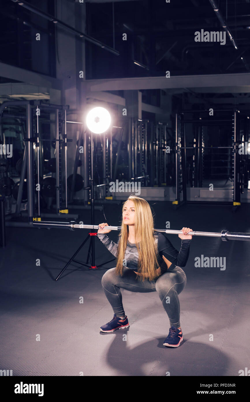 Pretty woman working out with barbell in a gym Stock Photo - Alamy