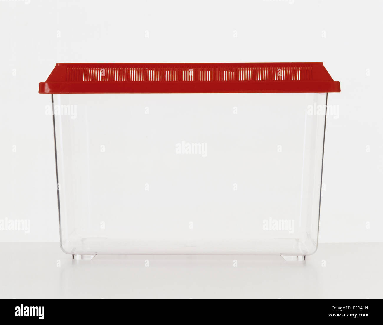 Clear plastic tank with red, holed lid Stock Photo - Alamy