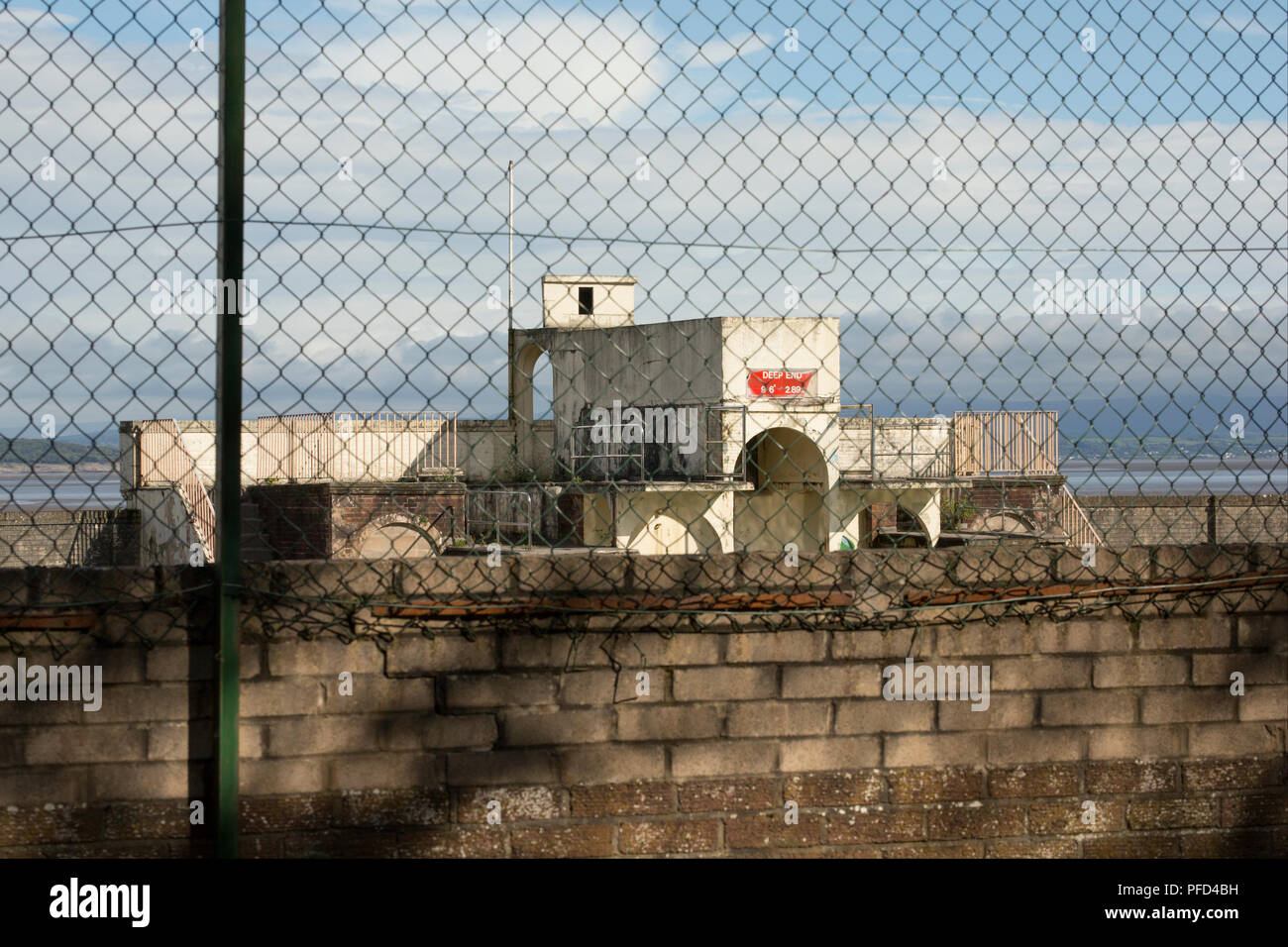 The derelict Lido at Grange Over Sands viewed through fencing on the ...