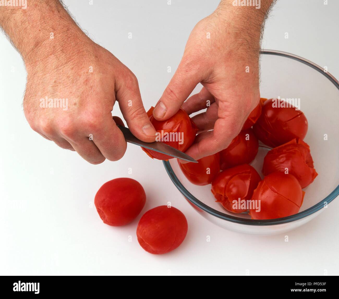Skinning tomatoes with a knife, close-up Stock Photo - Alamy
