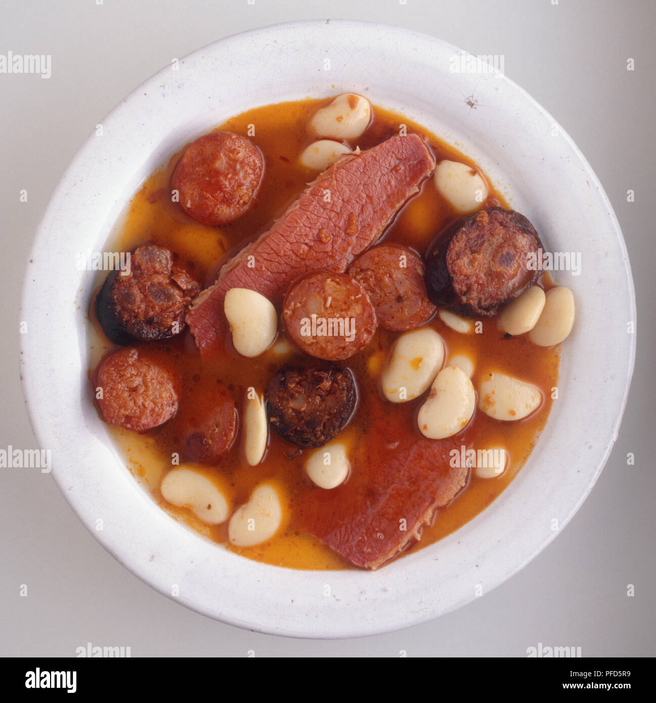 Bowl of Fabada, stew containing fava beans, beef, chorizo and morcilla ...