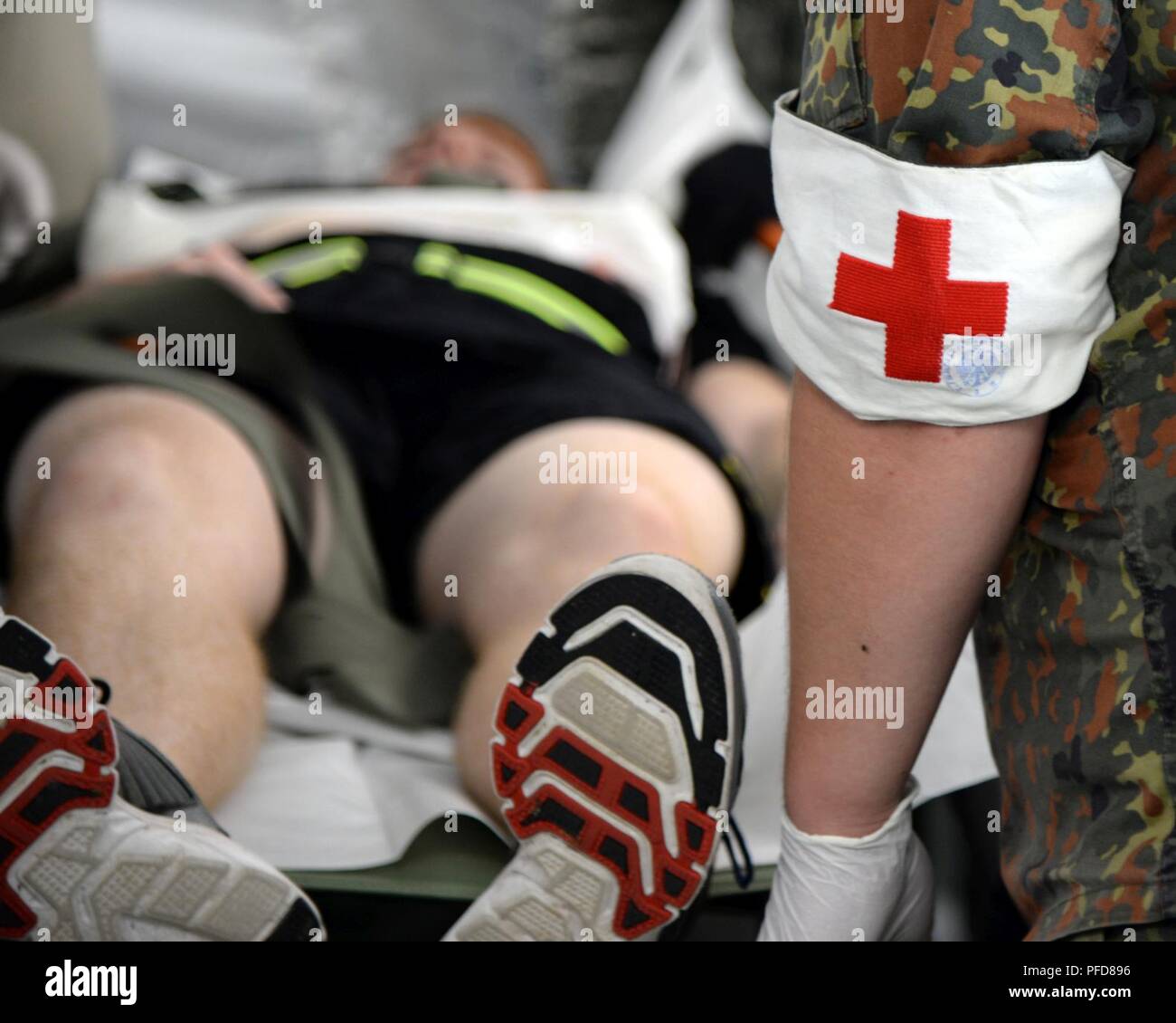 A German medic transports a patient to the emergency room tent during a ...