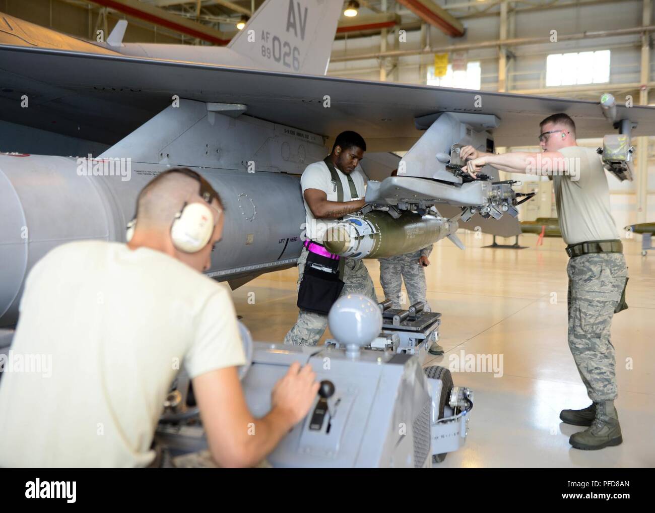A weapons load team load an inert munition during a training session ...