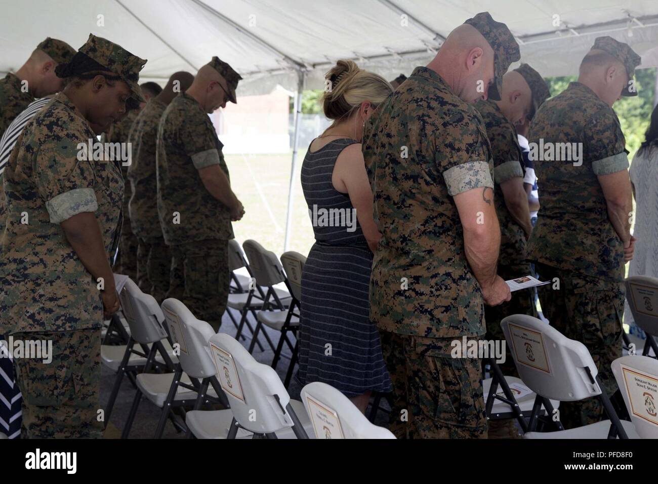 Marines and civilians bow their heads for the invocation during a ...