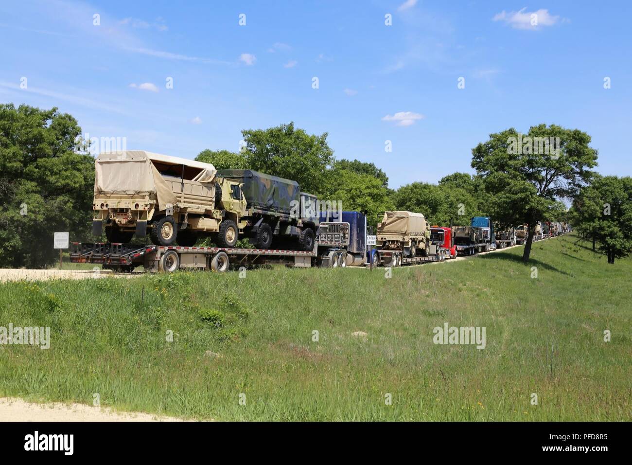 Tractor-trailers loaded with military equipment wait to get unloaded ...