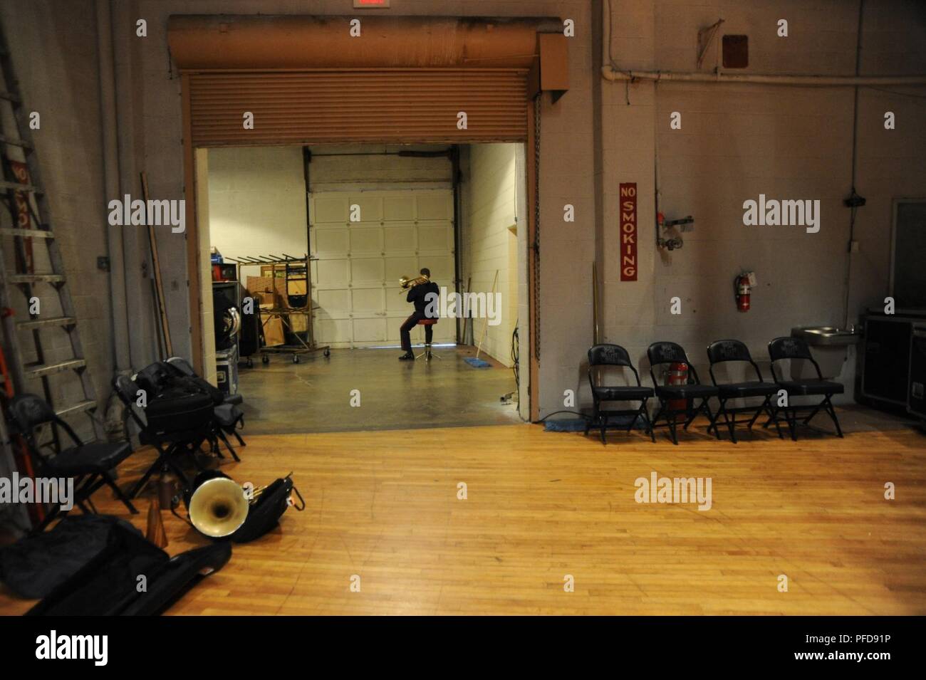 Musician 1st Class Wesley Mayhew warms up on the bass trombone before a ...