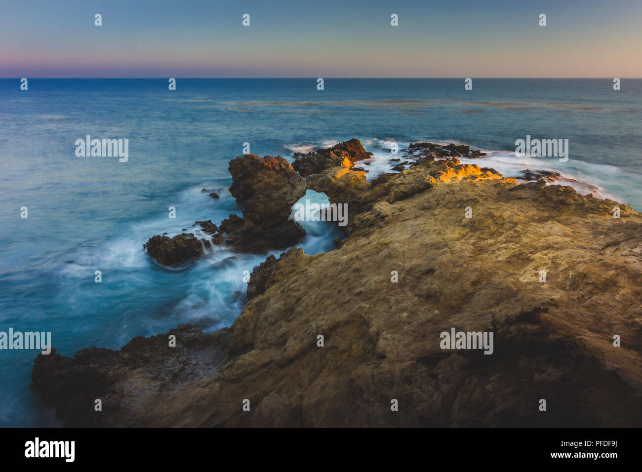Stunning long-exposure view of smooth waves crashing into rock ...