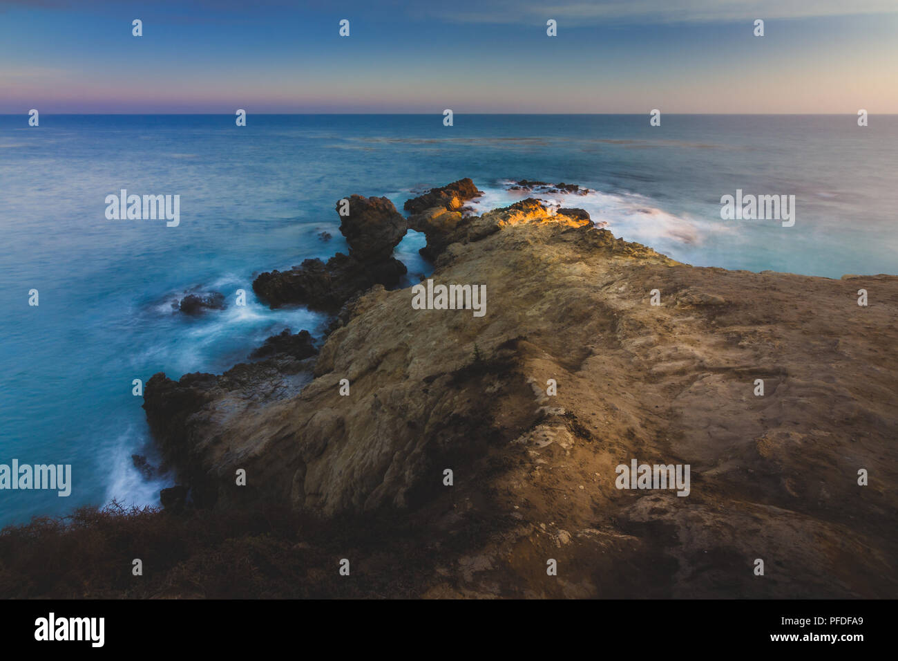 Stunning long-exposure view of smooth waves crashing into rock ...