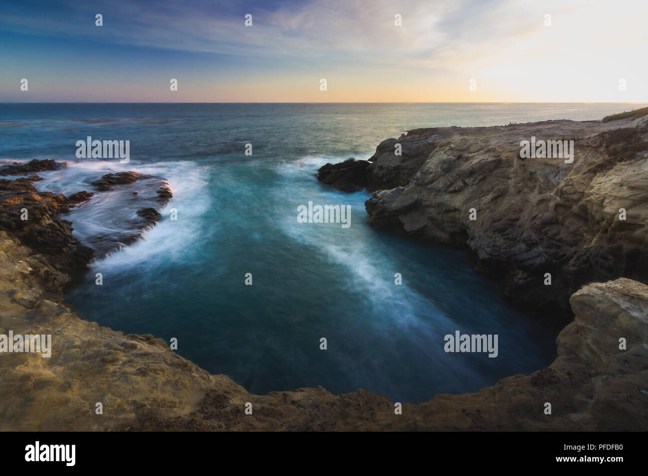 Stunning long-exposure view of smooth waves crashing into rock ...
