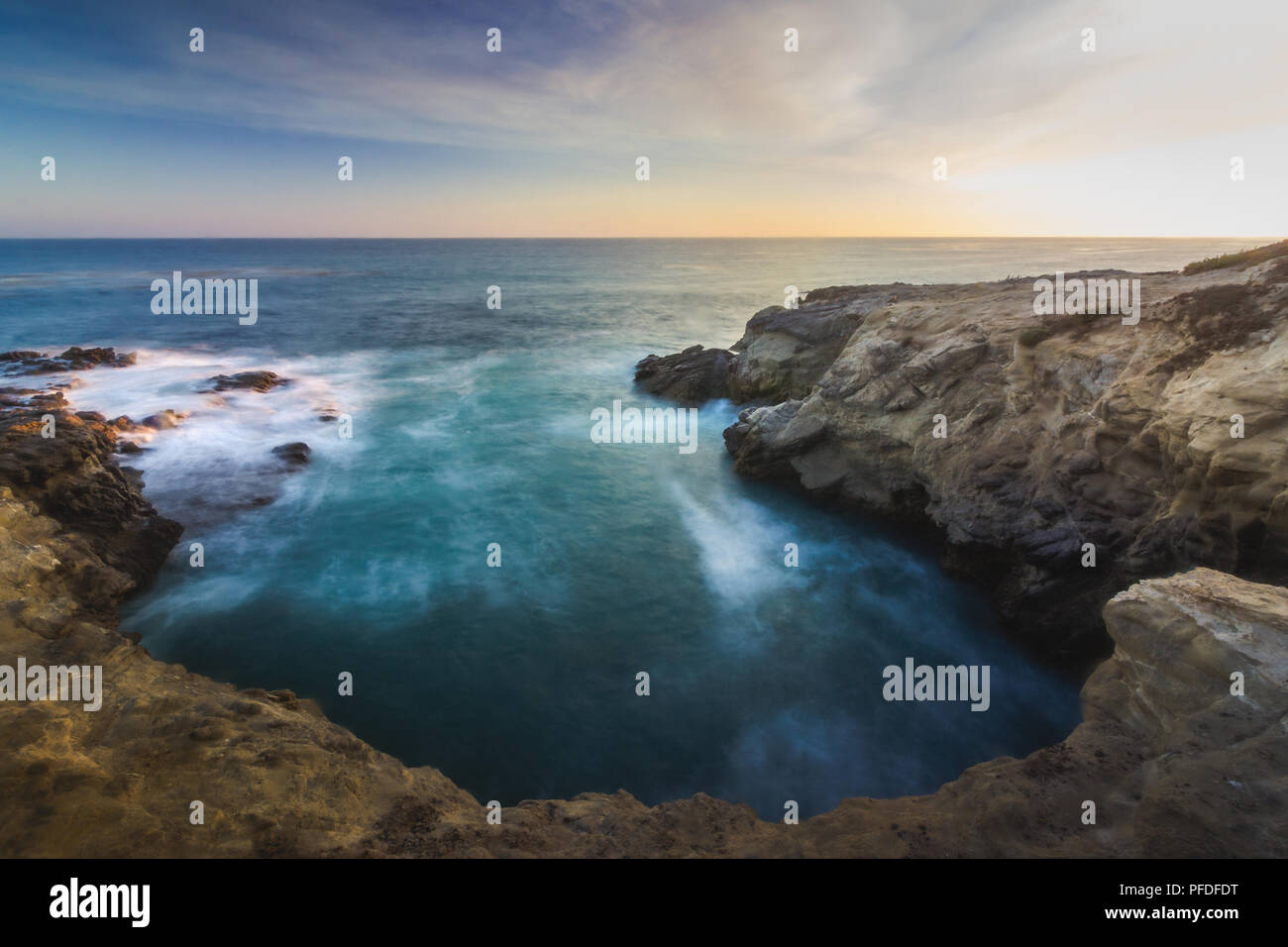 Stunning long-exposure view of smooth waves crashing into rock ...