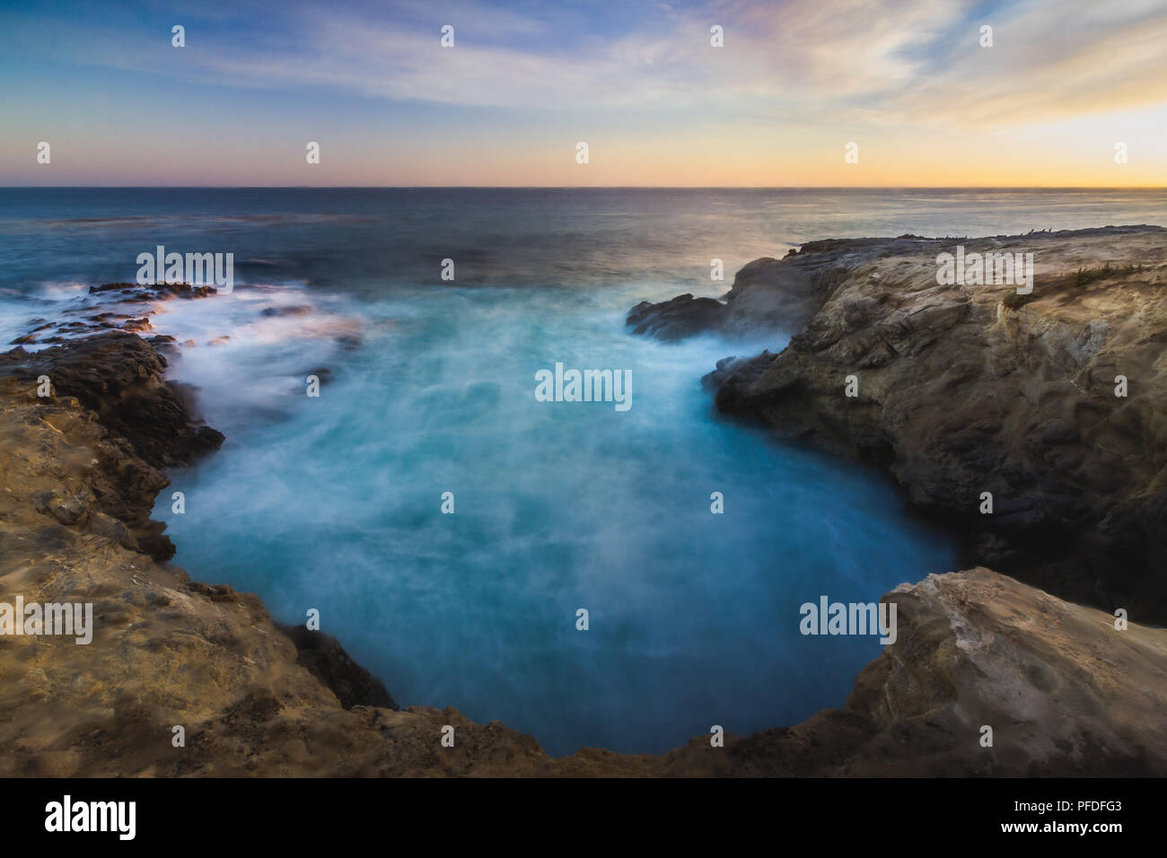 Stunning long-exposure view of smooth waves crashing into rock ...
