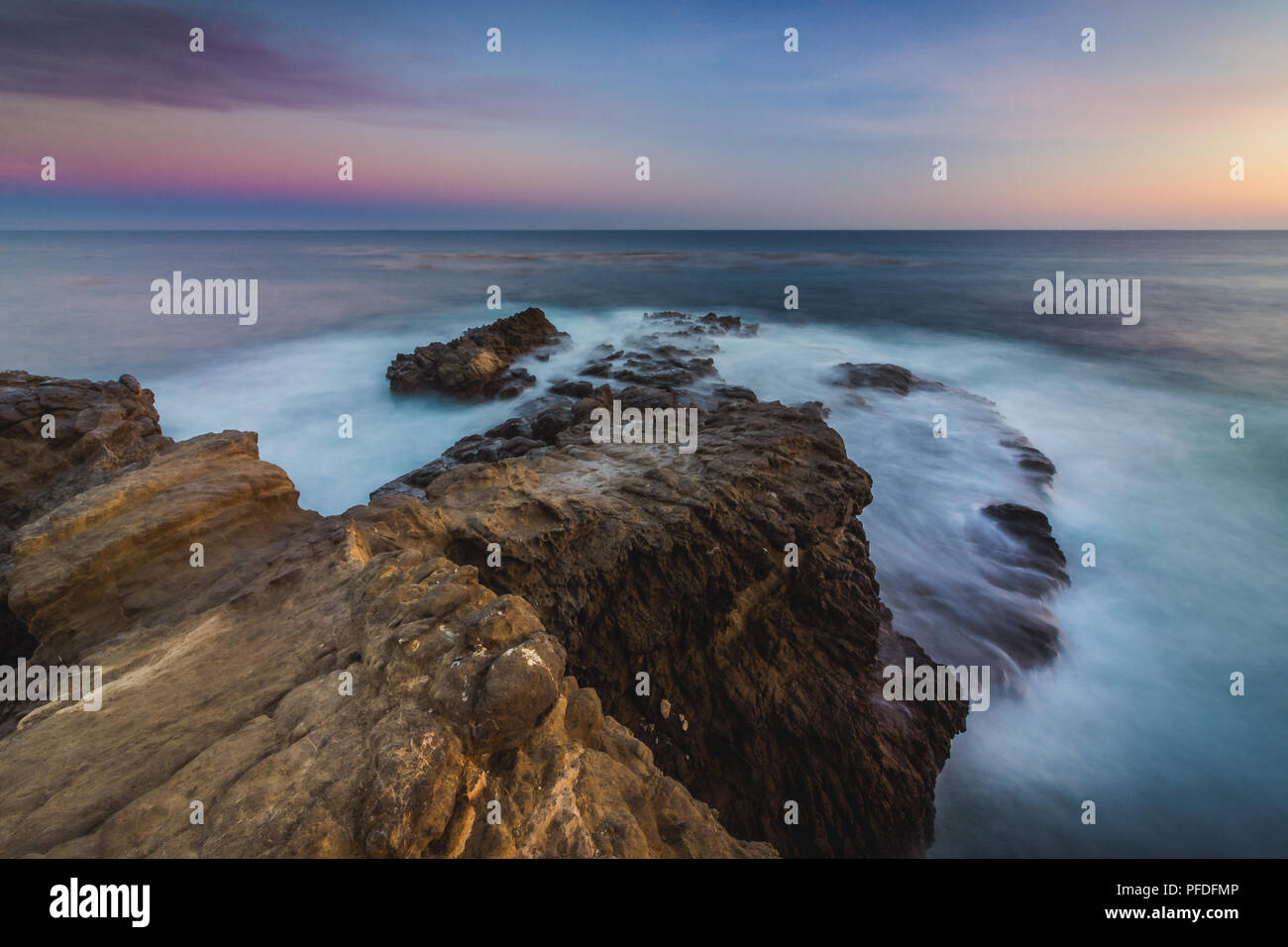 Stunning long-exposure view of smooth waves crashing into rock ...