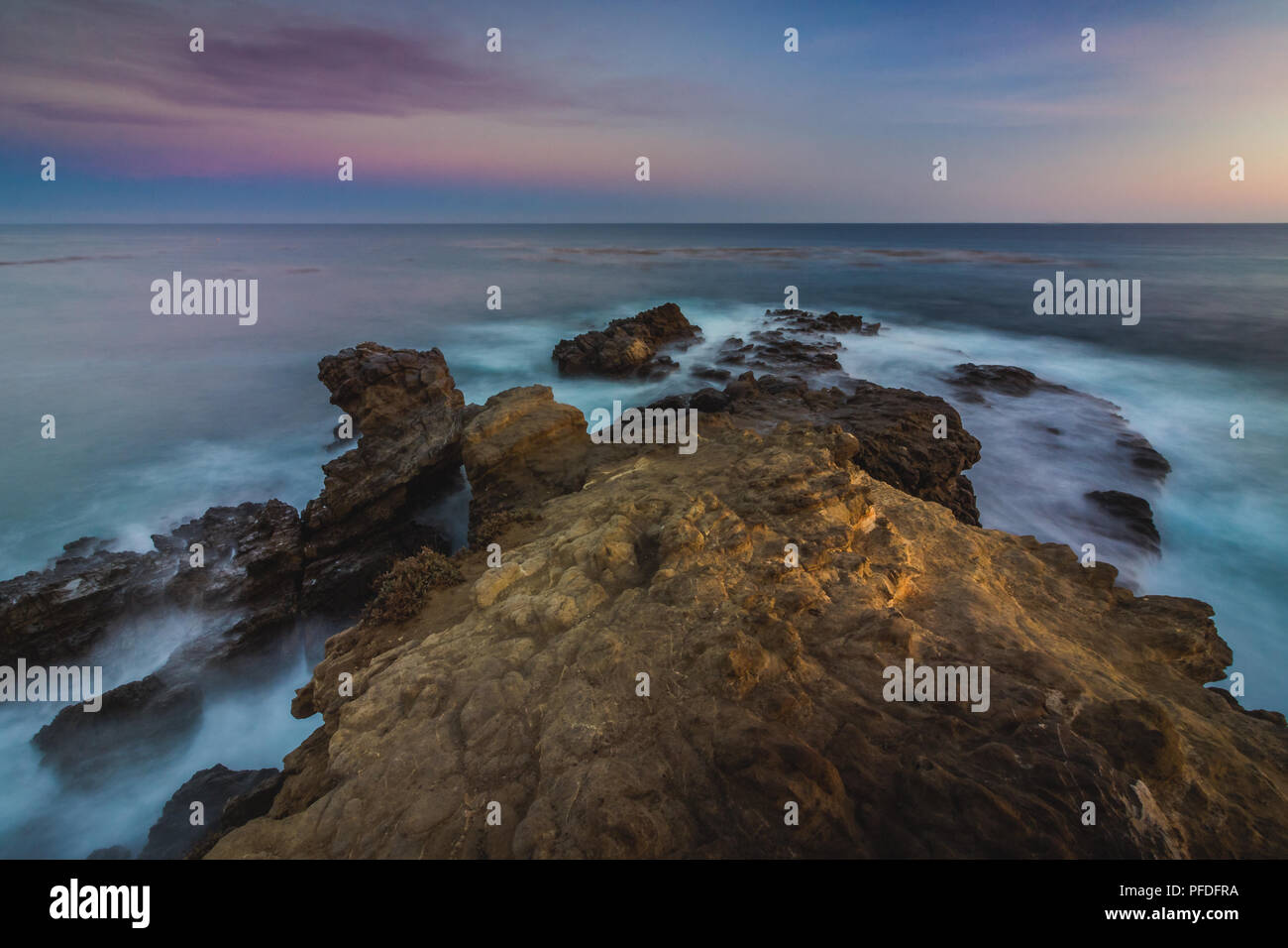 Stunning long-exposure view of smooth waves crashing into rock ...