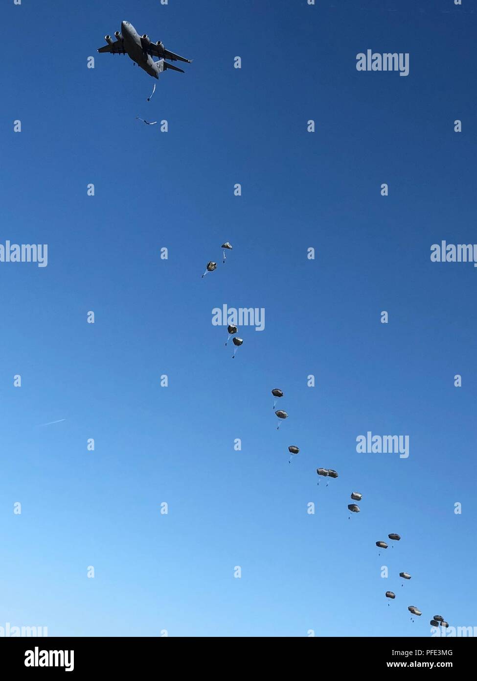 Paratroopers jump from a C-17 as part of an airborne insertion exercise ...