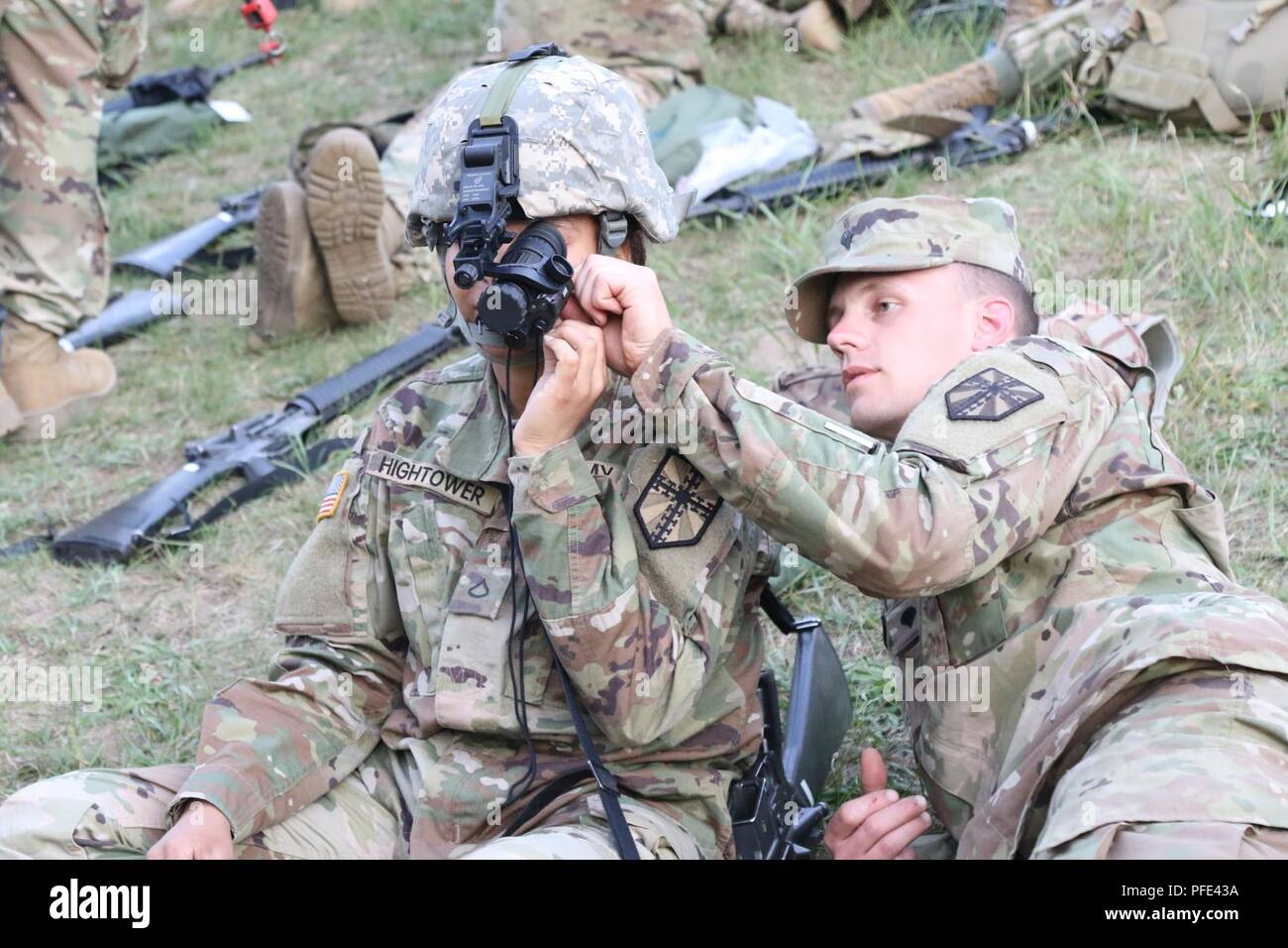 Spc. Collin A. Miller assists Pfc.l Lushell J. Hightower with adjusting ...