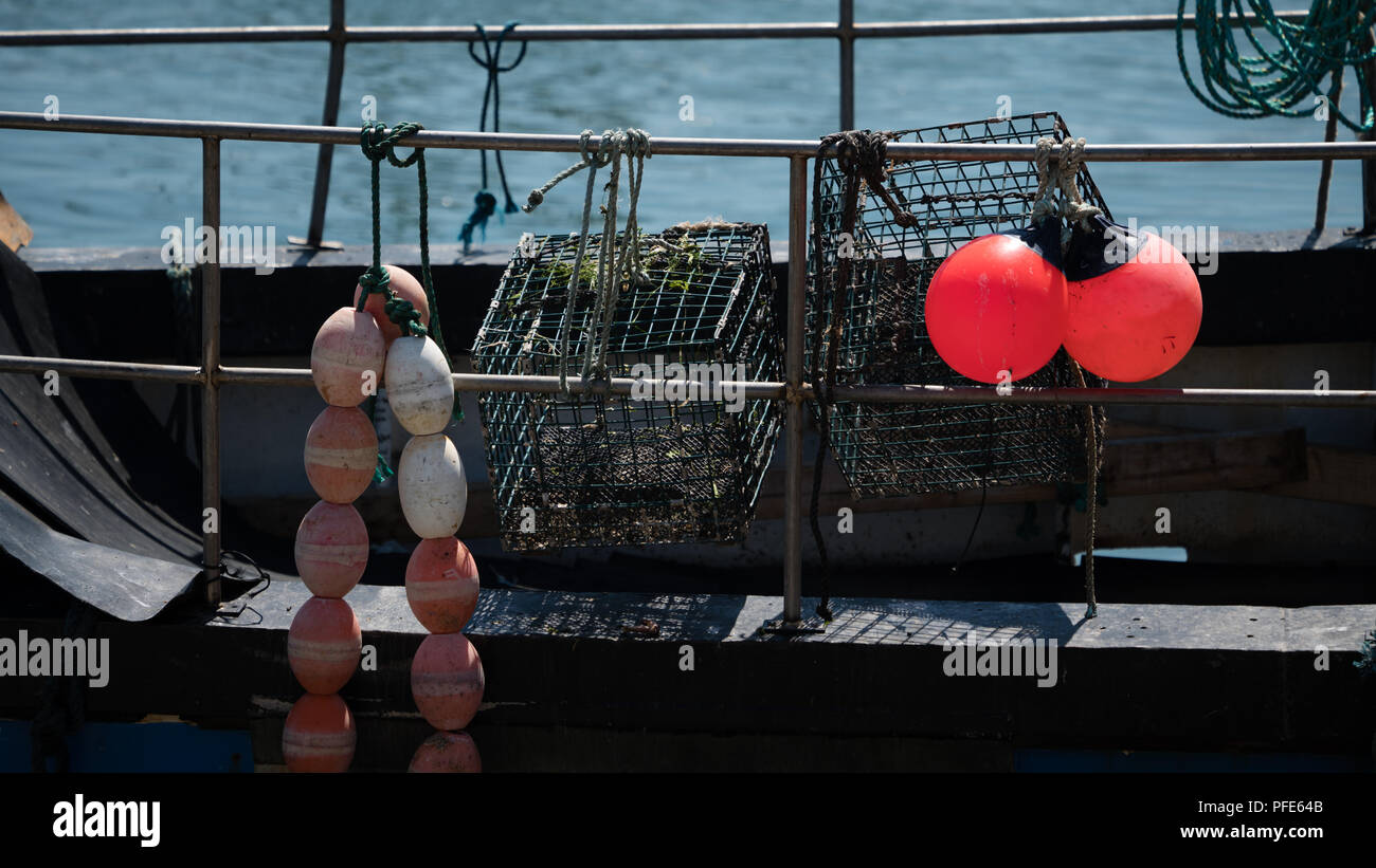 Commercial fishing boat with crab traps and bright buoy on the rail ...